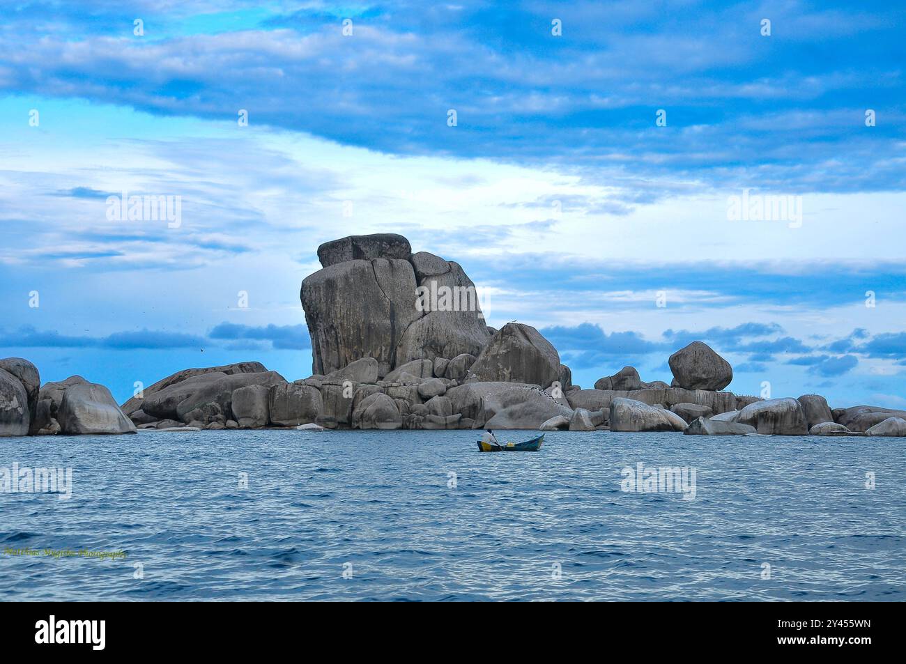 A fisherman passes below towering rocks in Dolwe Island Lake Victoria ...