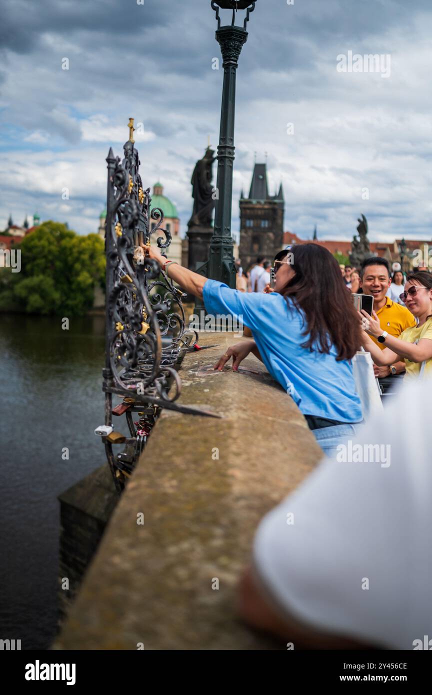 Tourists touching a plaque in Charles Bridge for good luck, Prague ...