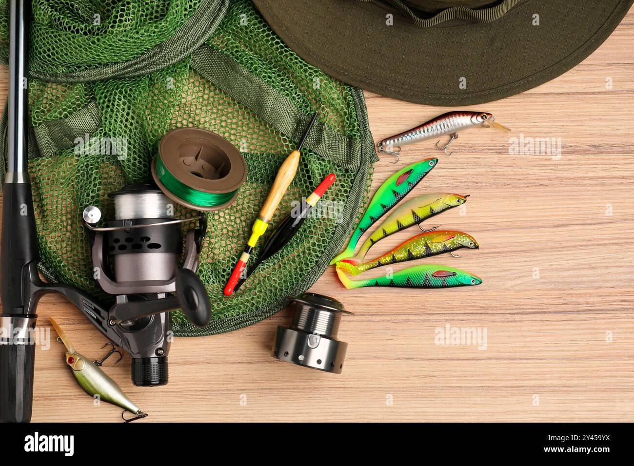 Fishing rod with spinning reel, baits, hat, net, floats and line on ...