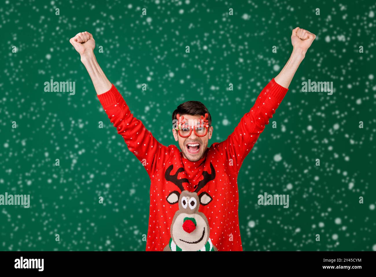 Portrait of attractive cheerful guy having fun rising hands up ...