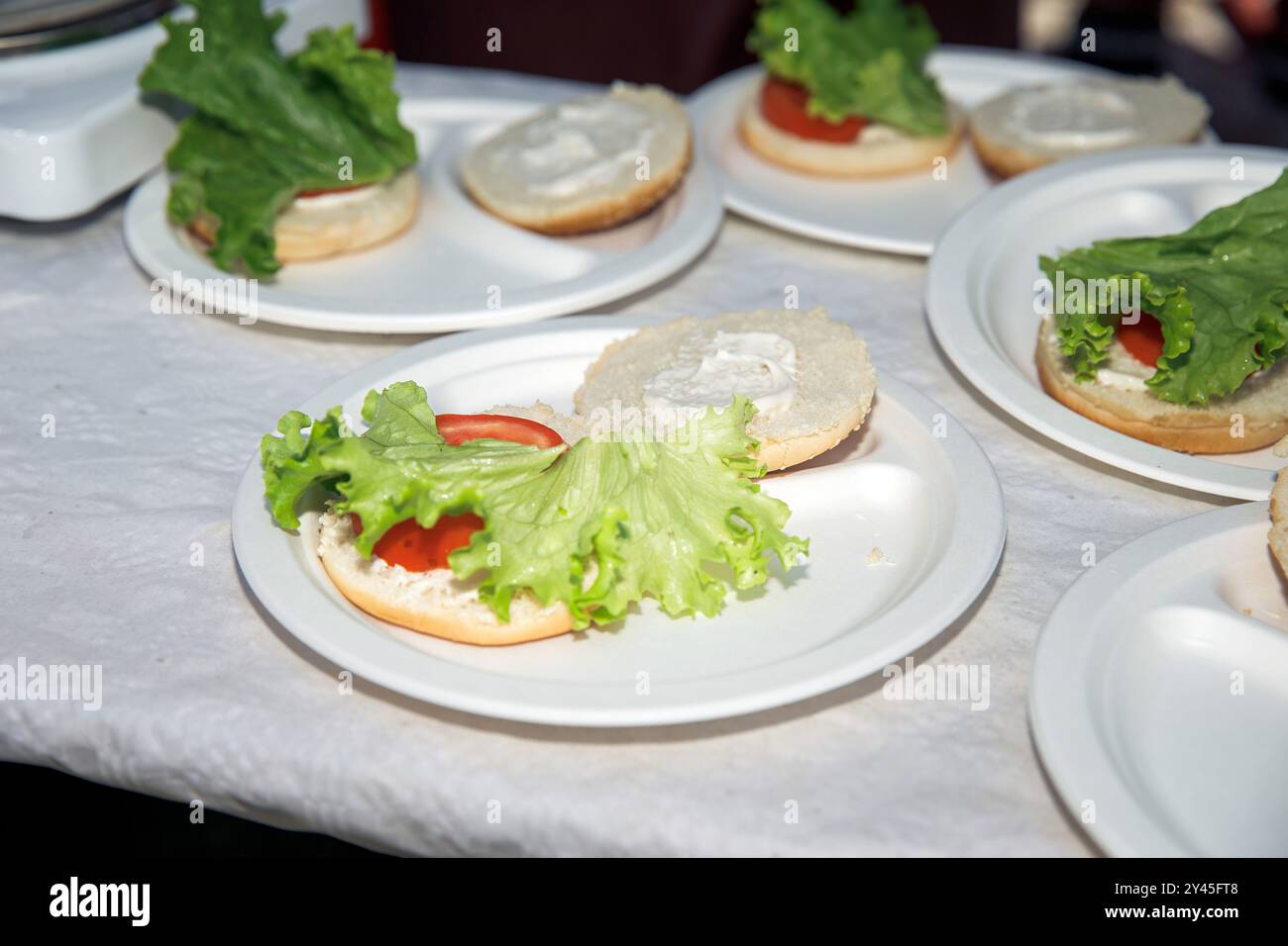 Preparing open face sandwiches with fresh lettuce, tomato, and mayo on ...