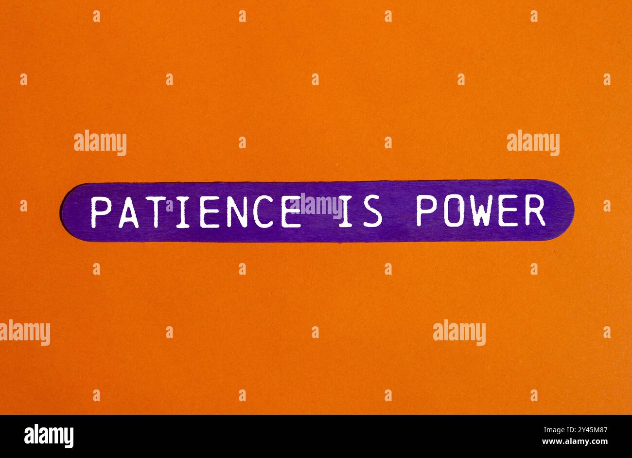 Patience is power message written on purple wooden stick on orange ...