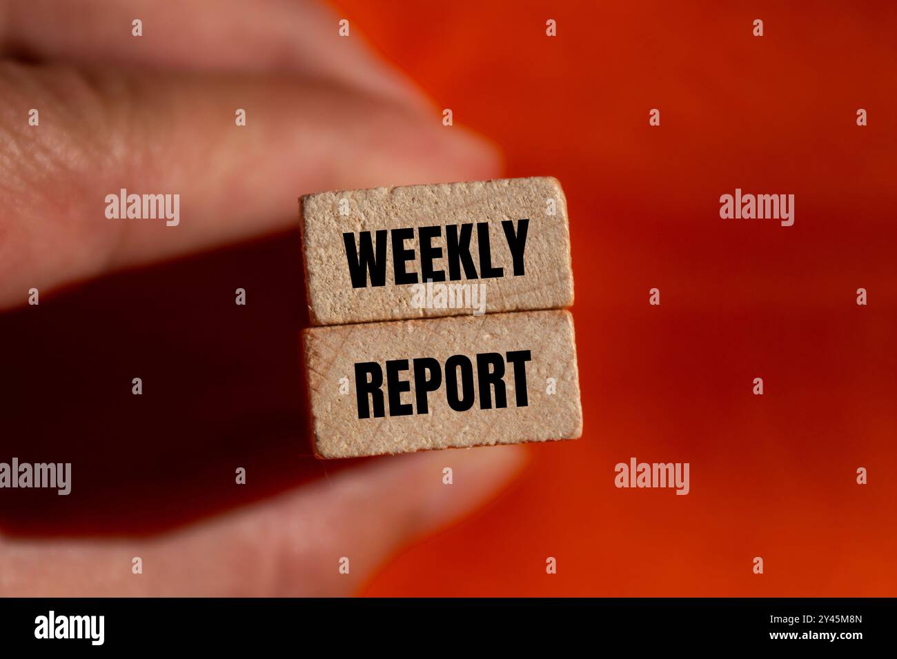 Weekly report message written on wooden blocks with orange background ...