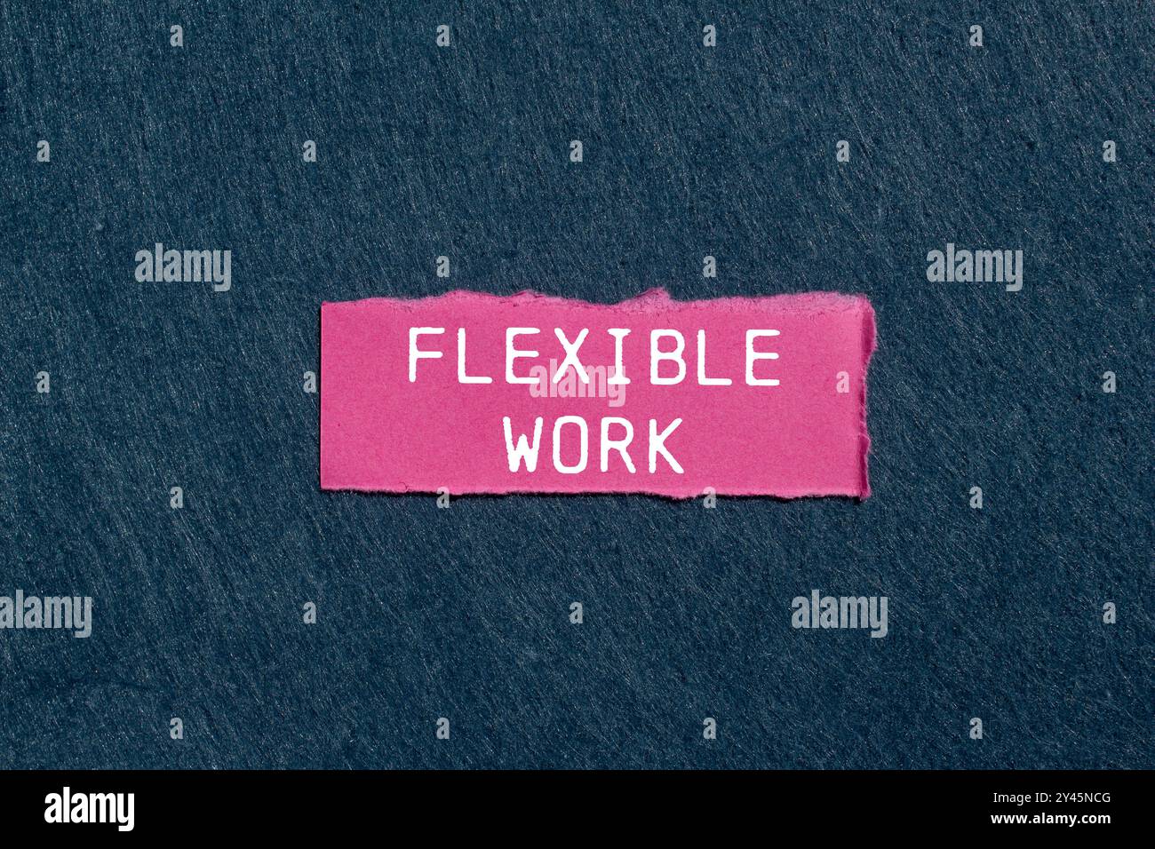 Flexible work message written on ripped pink torn paper piece on gray background. Conceptual ...