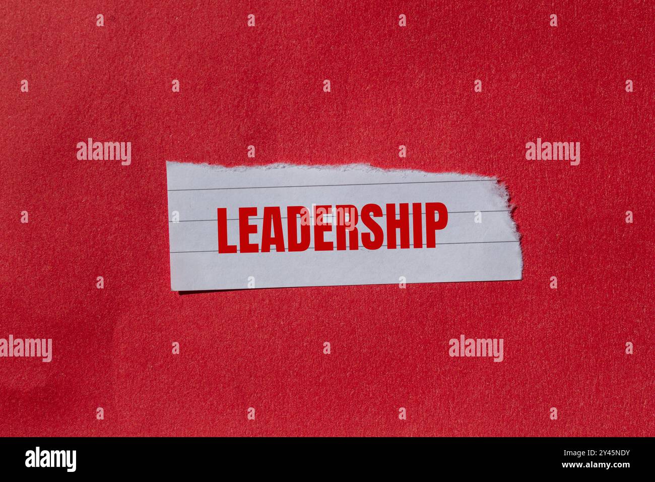 Leadership message written on ripped torn paper piece with red background. Conceptual leadership ...