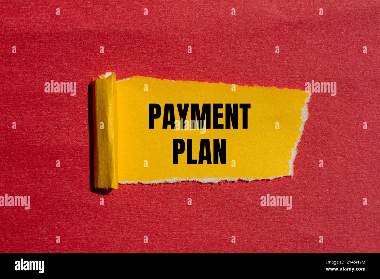 Payment plan message written on ripped torn yellow paper with red background. Conceptual payment ...
