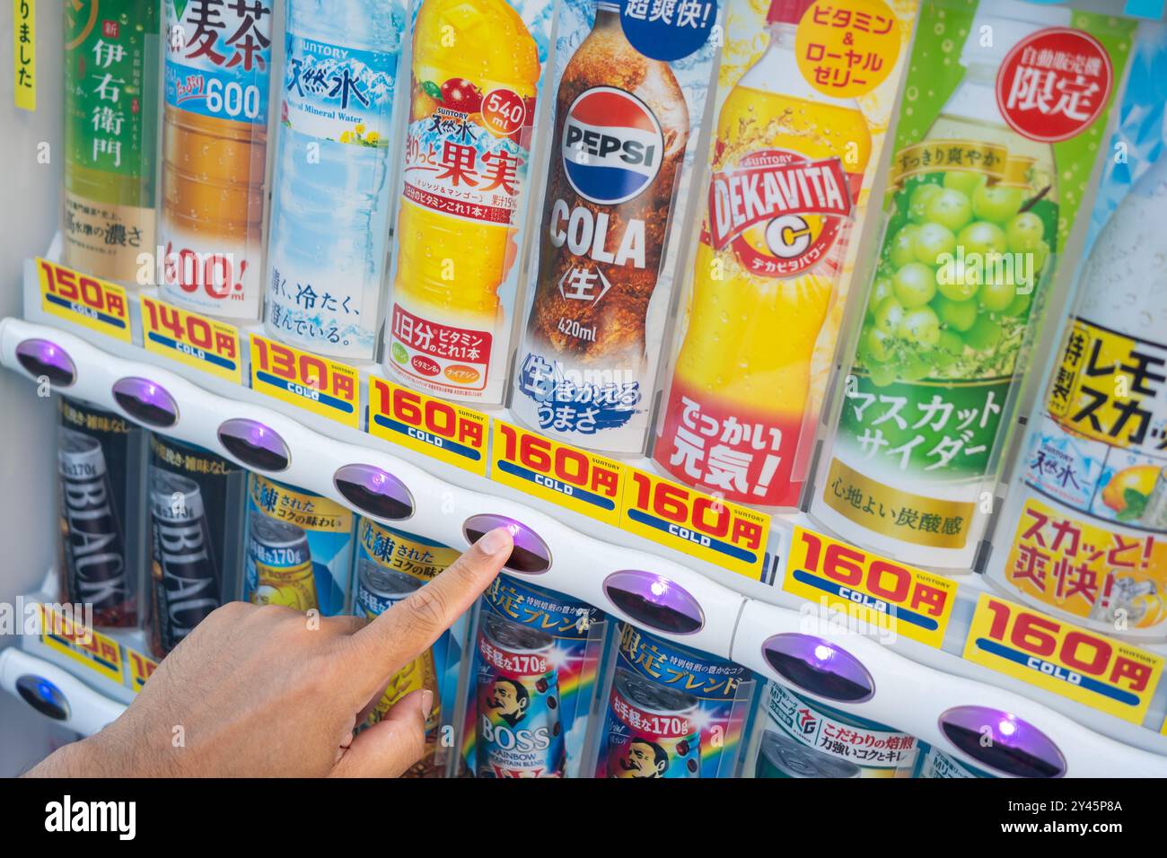 A finger presses a button to buy Pepsi cola from a Japanese vending ...