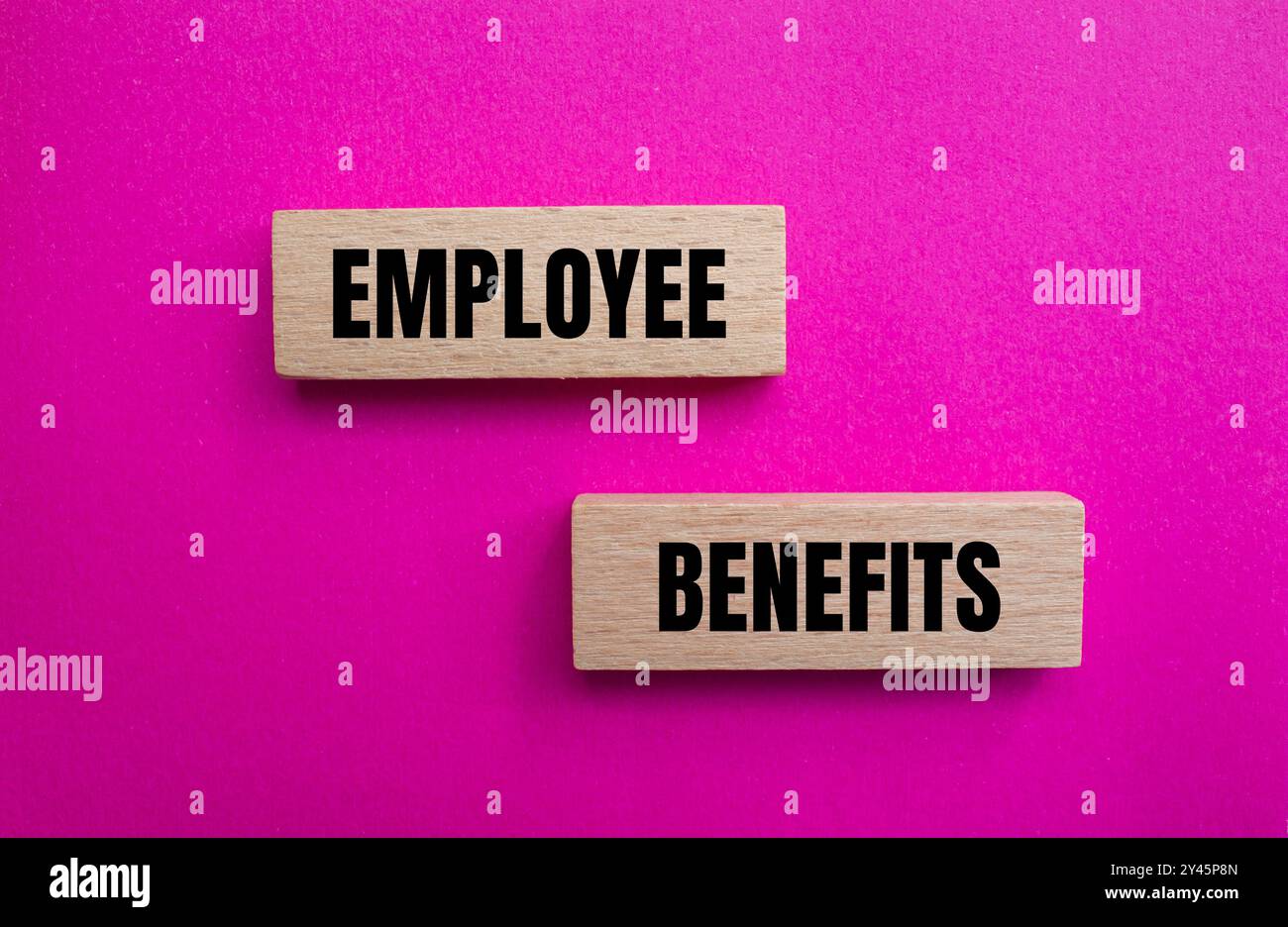 Employee benefits message written on wooden blocks with pink background ...