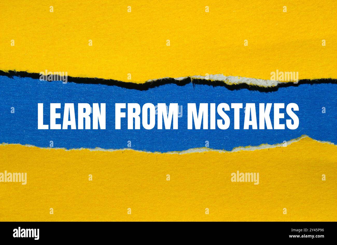 Learn from mistakes message written on ripped torn yellow paper with blue background. Conceptual ...