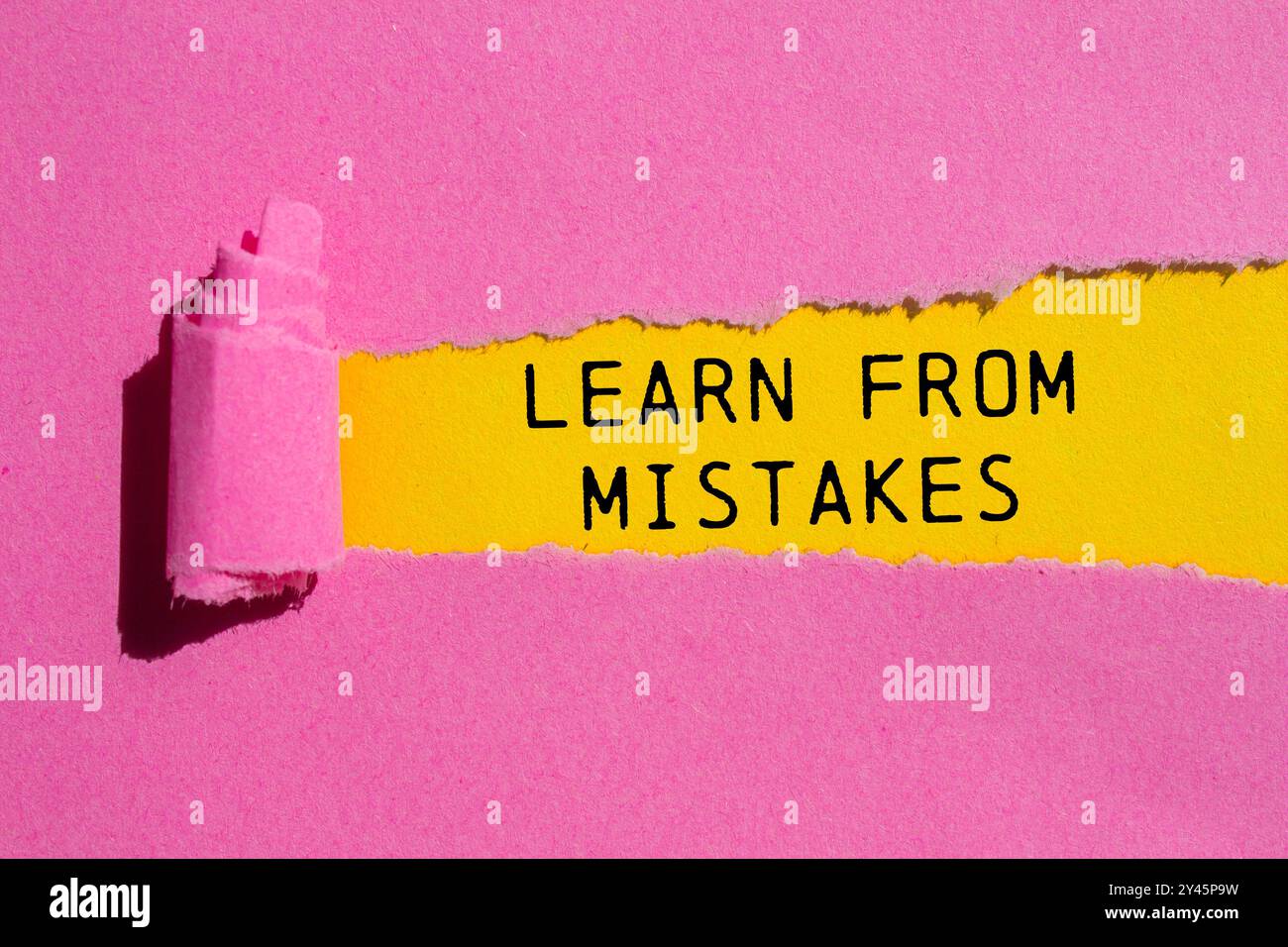 Learn from mistakes message written on ripped torn pink paper with yellow background. Conceptual ...