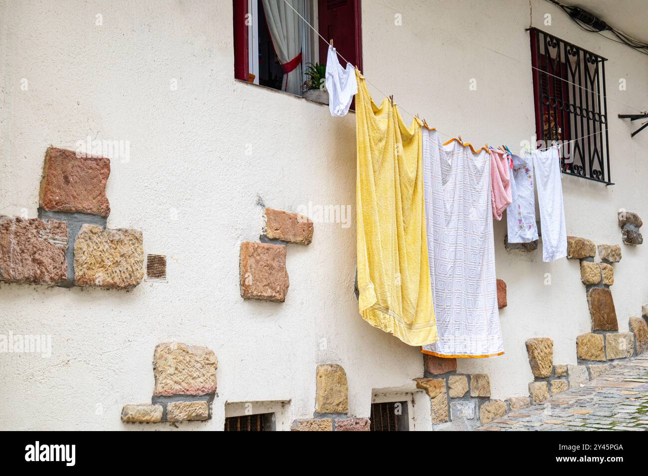 Old house with clothesline between window and window, drying clothes ...