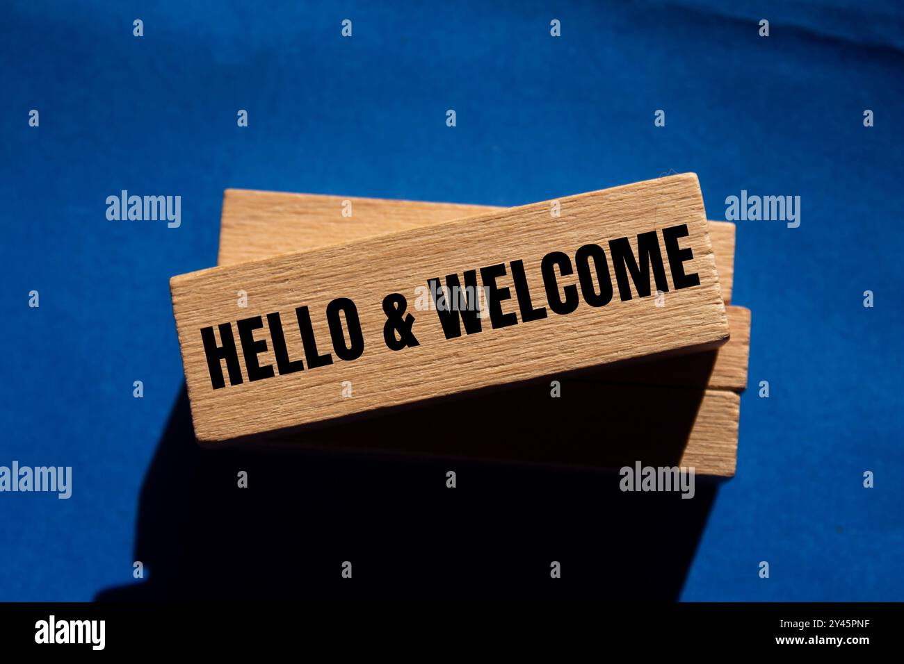 Hello and welcome message written on wooden blocks on blue background ...