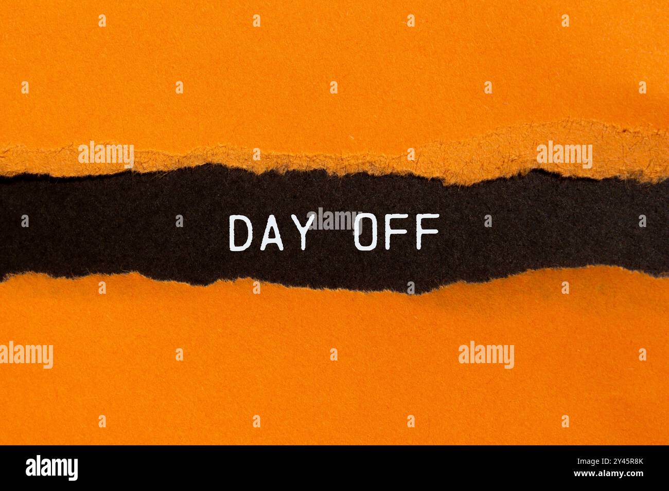 Day off message written on ripped torn orange paper on black background ...