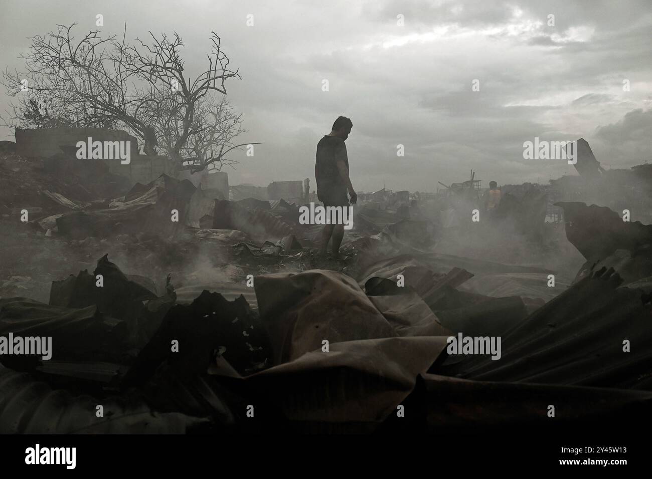 Aftermath of a fire in the Bacoor, Cavite, south of Manila A man looks ...