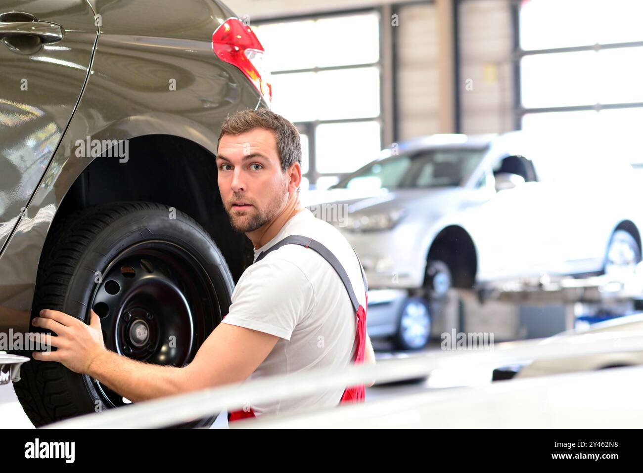 portrait of a friendly car mechanic in the workshop in work clothes ...