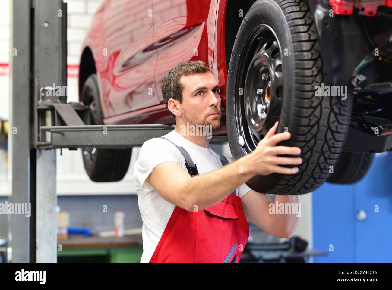 professional car mechanic works in a workshop and repairs vehicles ...