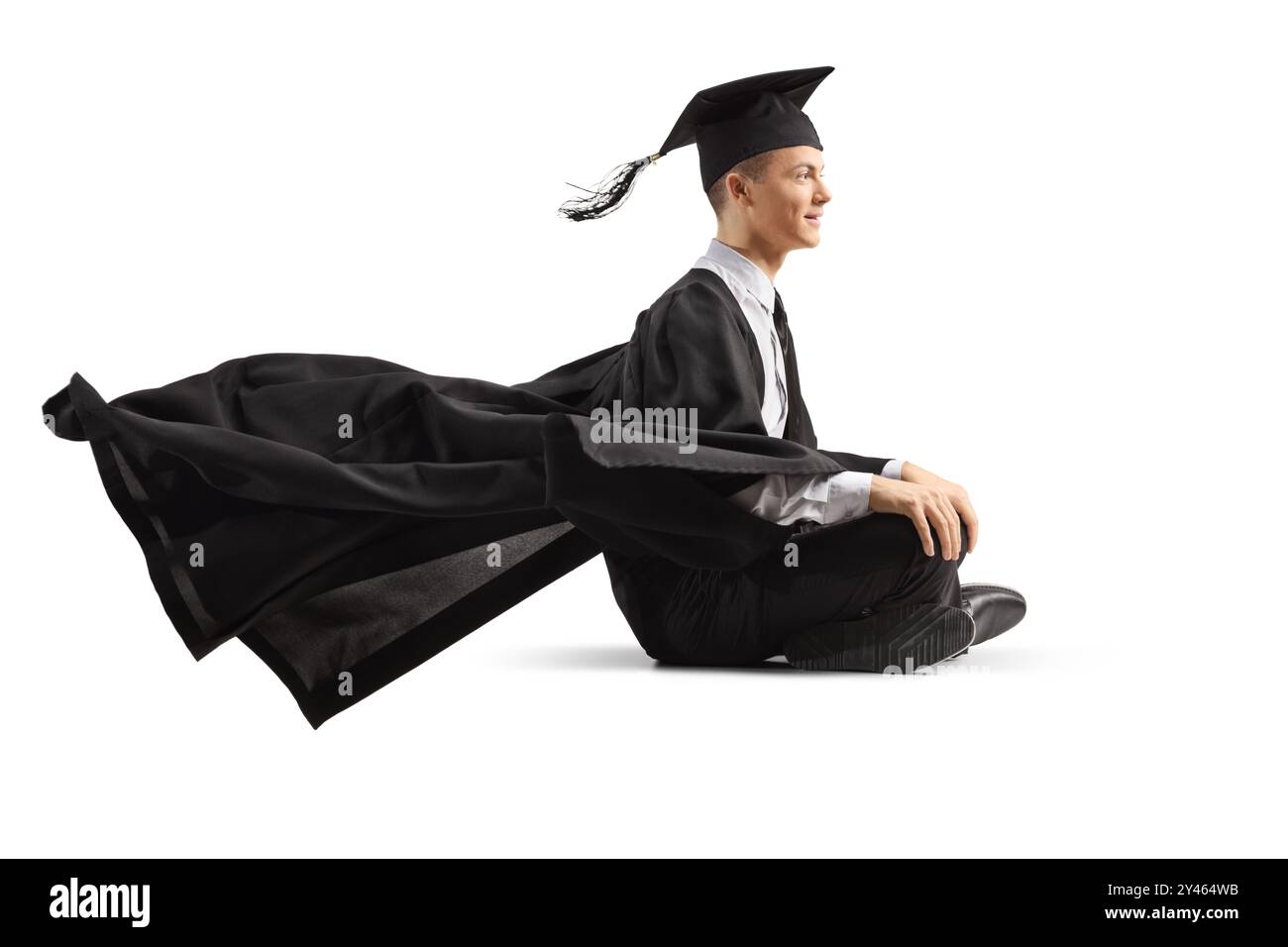 Graduate student in a gown sitting on the ground isolated on white ...