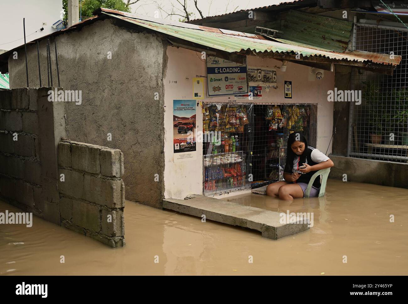 Philippines Typhoon Yagi Women wade along a flooded street caused by ...