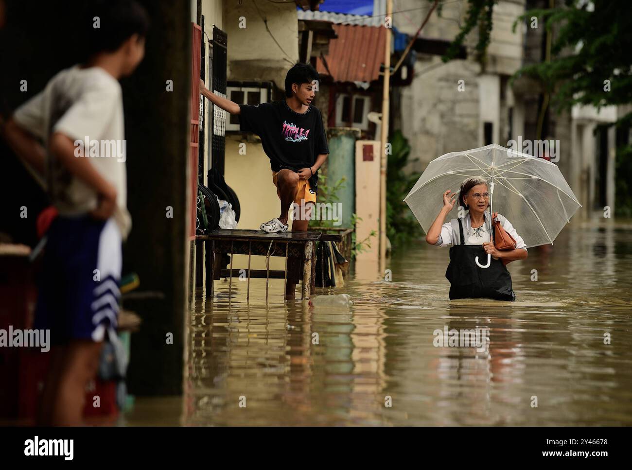 Philippines Typhoon Yagi People wade through a flooded street caused by ...