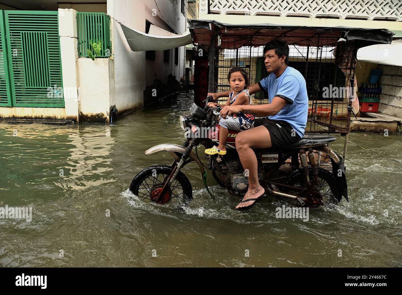 Flooding caused by typhoon Yagi in Philippines A man drives a passenger ...