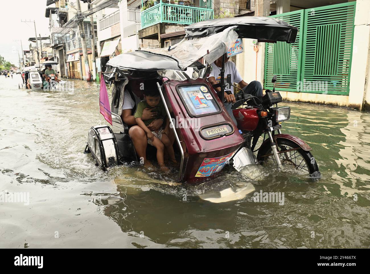 Flooding caused by typhoon Yagi in Philippines A man drives a passenger ...