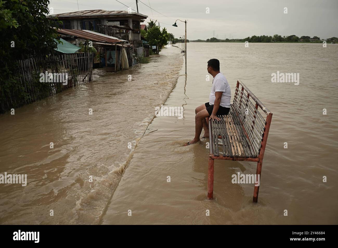 Philippines Typhoon Yagi A man sits on a bench as the Pampanga river ...