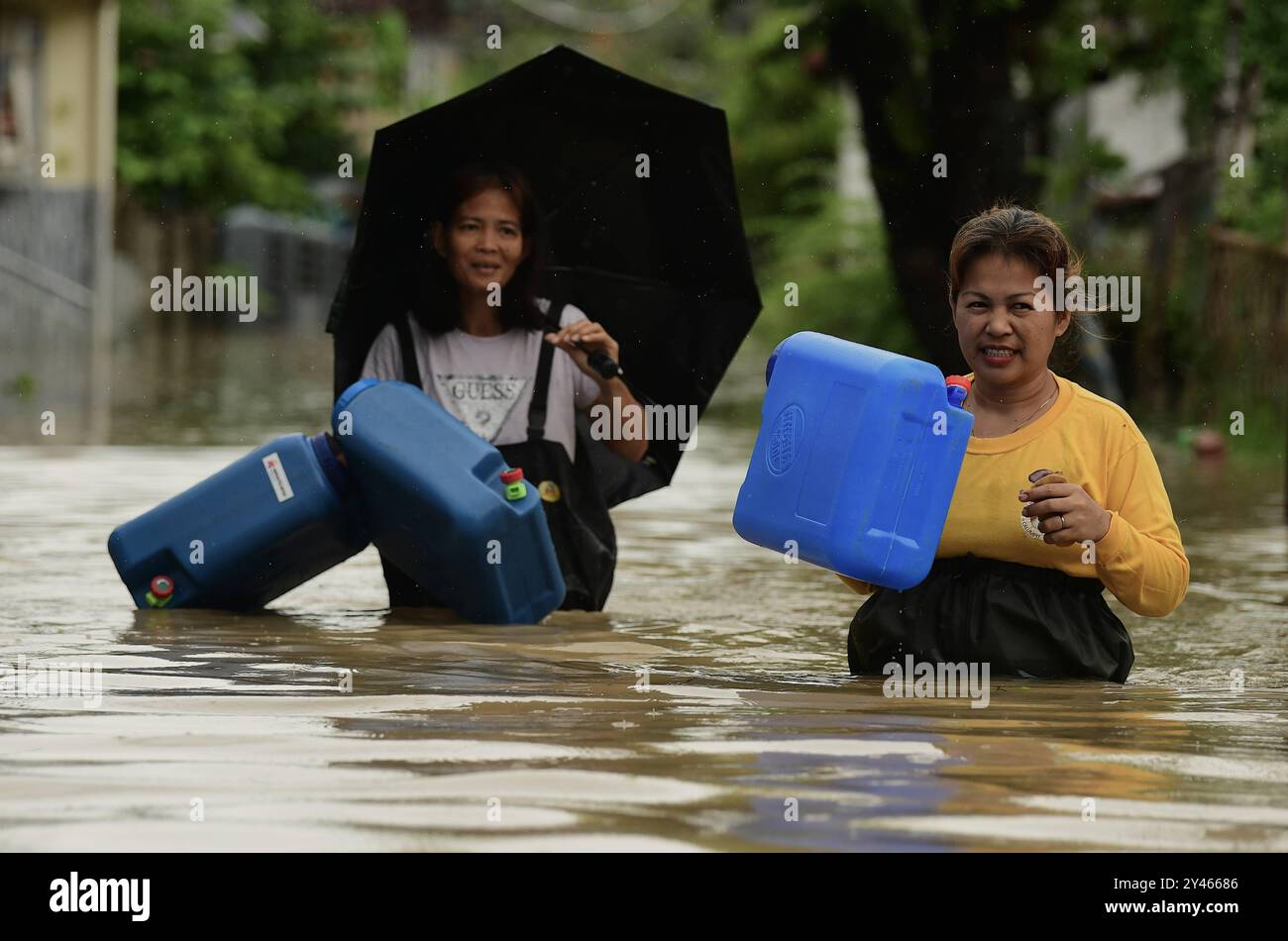 Philippines Typhoon Yagi People wade through a flooded street caused by ...