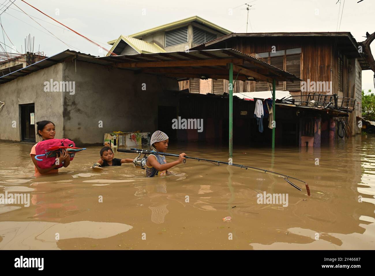Flooding caused by typhoon Yagi in Philippines People wade through a ...