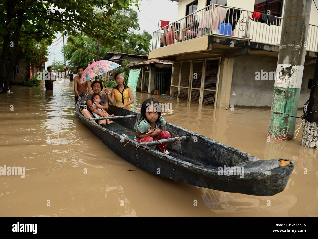 Flooding caused by typhoon Yagi in Philippines People ride on a wooden ...