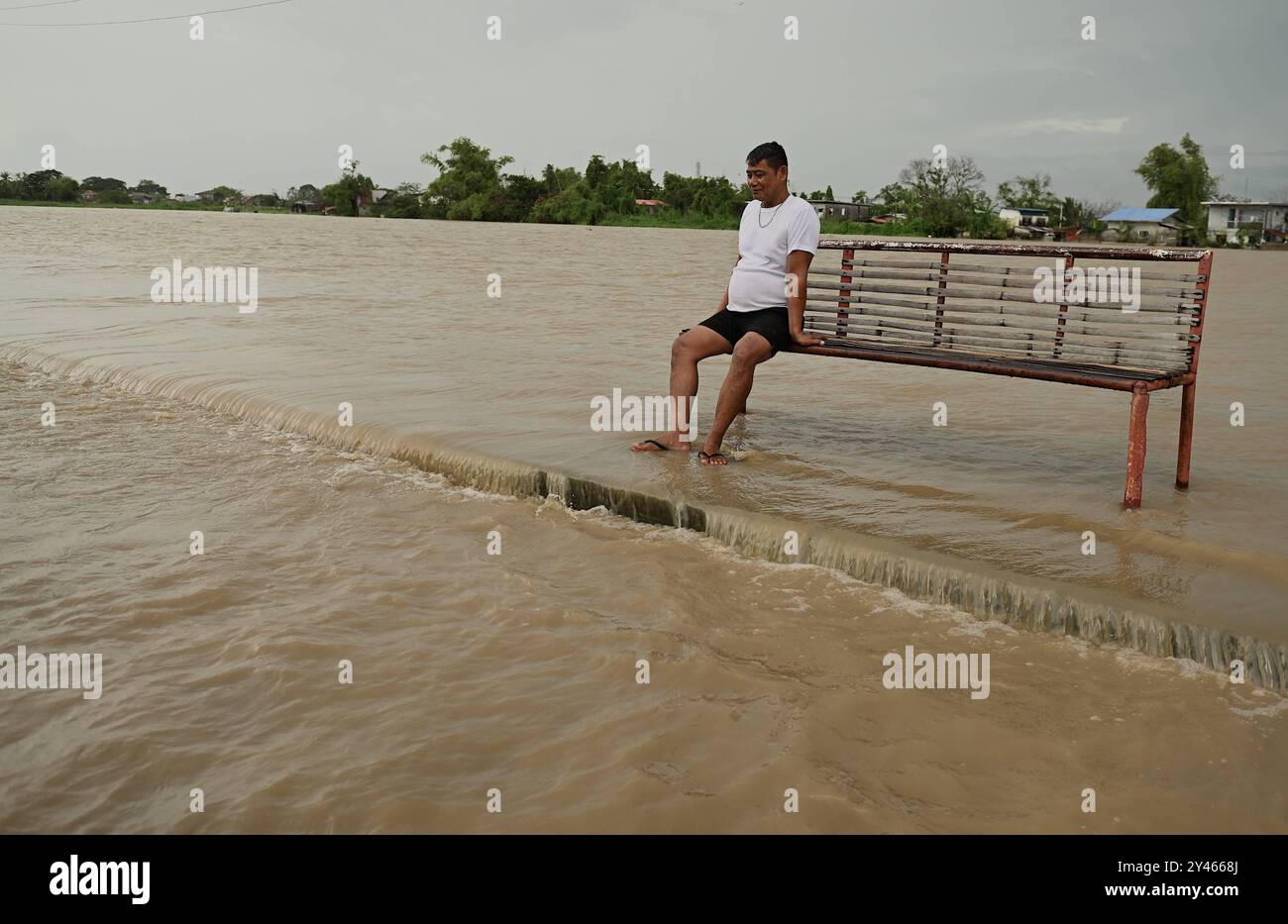 Philippines Typhoon Yagi A man sits on a bench as the Pampanga river ...