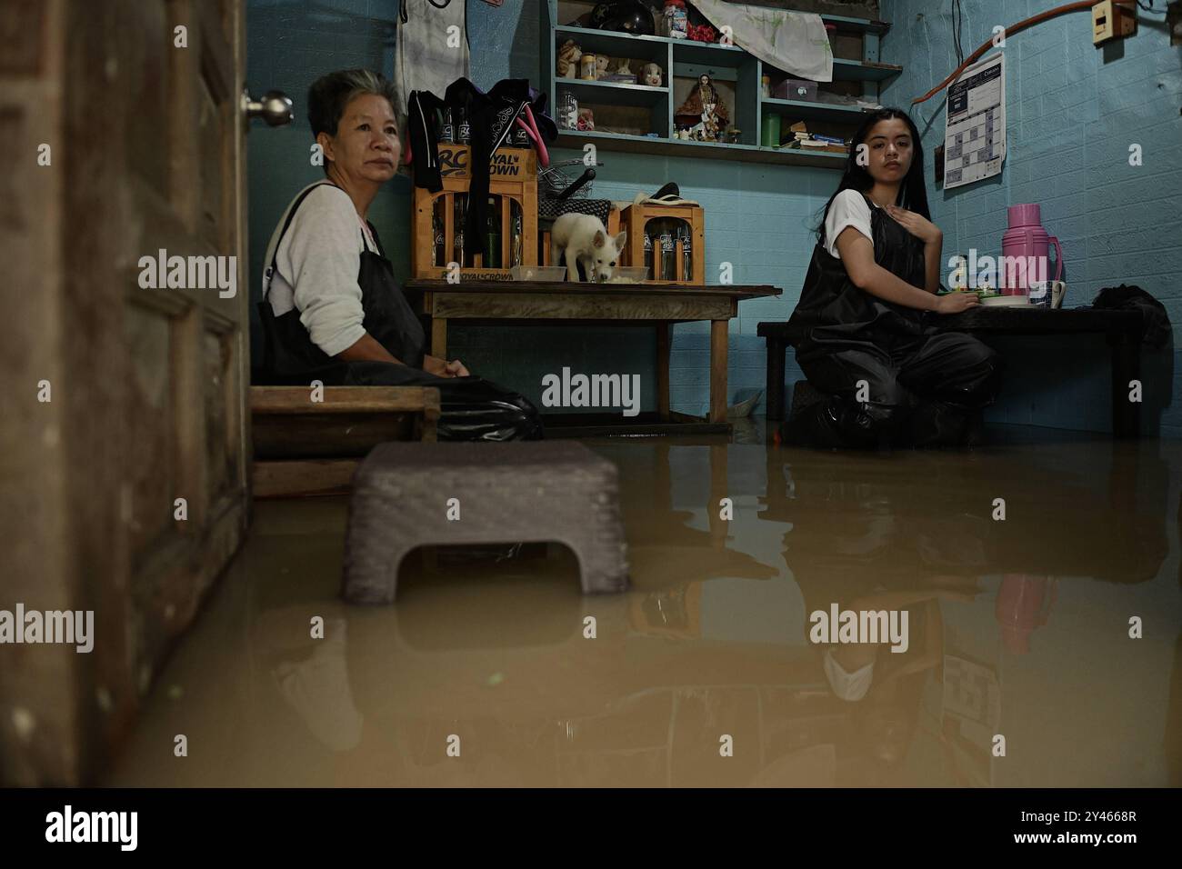 Philippines Typhoon Yagi Women are seen inside their flooded house ...