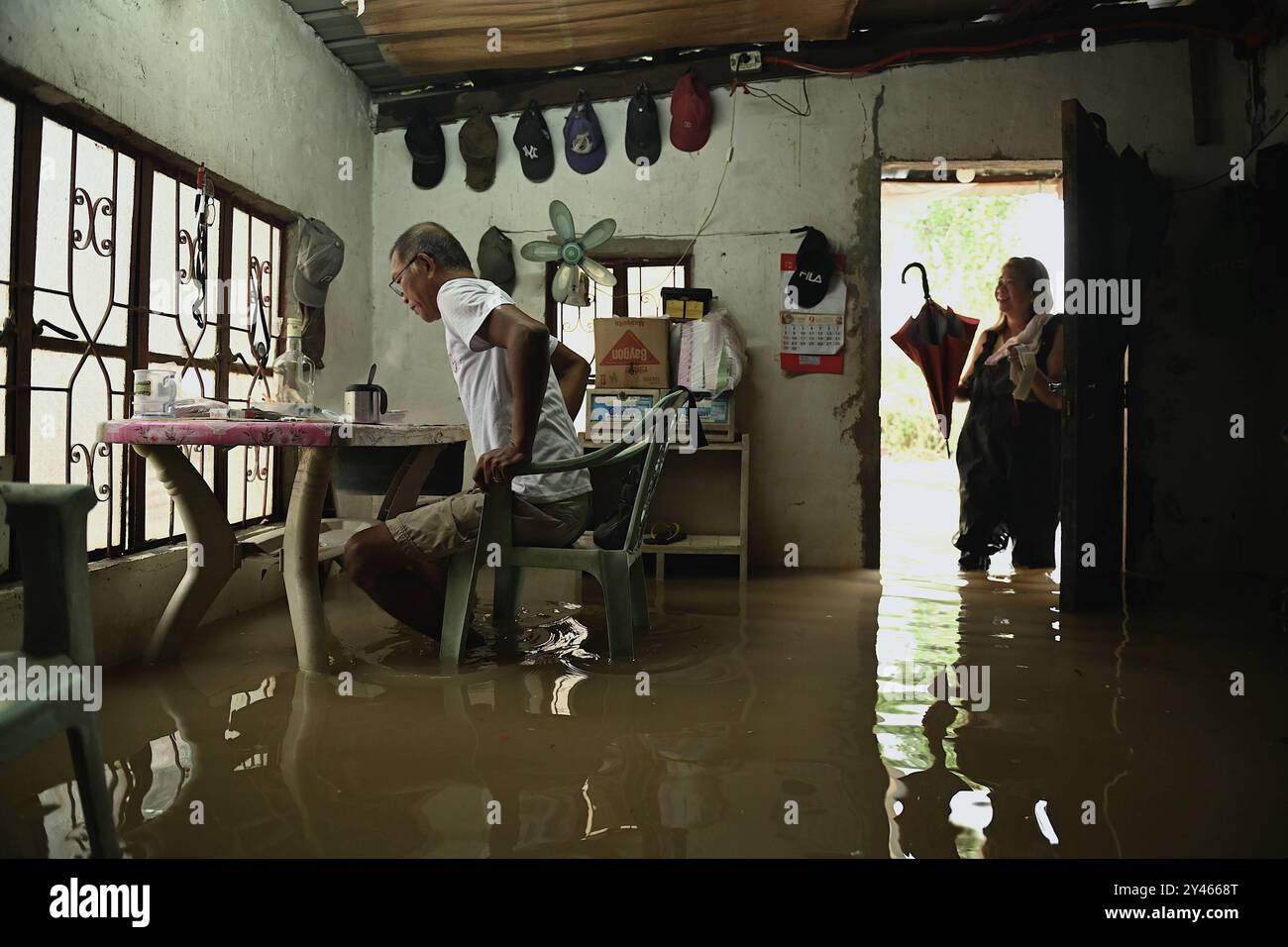 Philippines Typhoon Yagi A man sits on his table inside his flooded ...