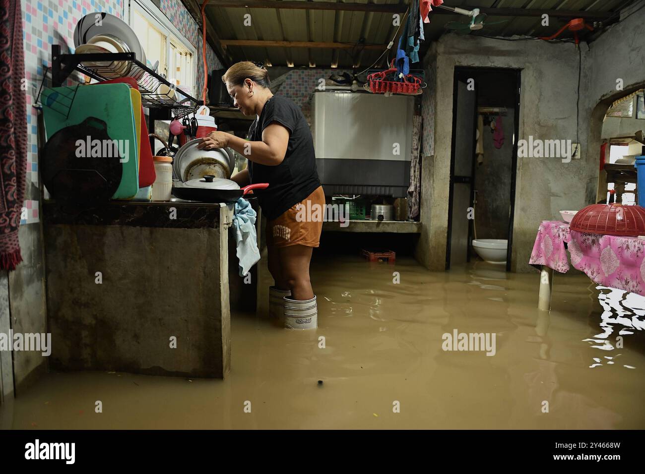 Philippines Typhoon Yagi A woman cooks launch inside her flooded house ...