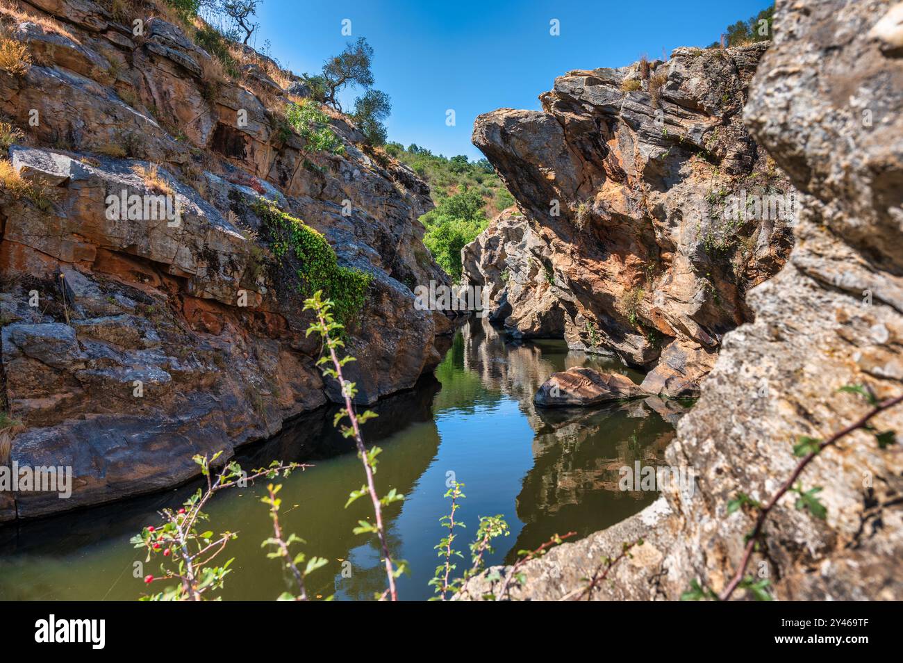 Narrow rocky gorge with still green water at Pego das Pias, a hidden ...