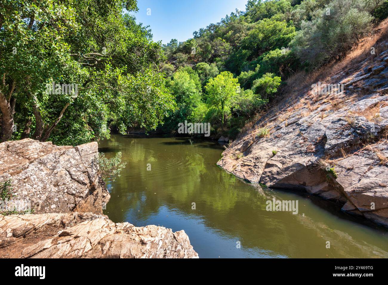 Narrow rocky gorge with still green water at Pego das Pias, a hidden ...