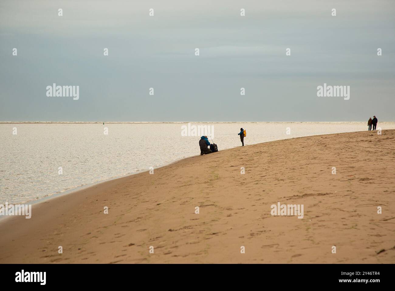 People sea fishing on a beach Stock Photo - Alamy