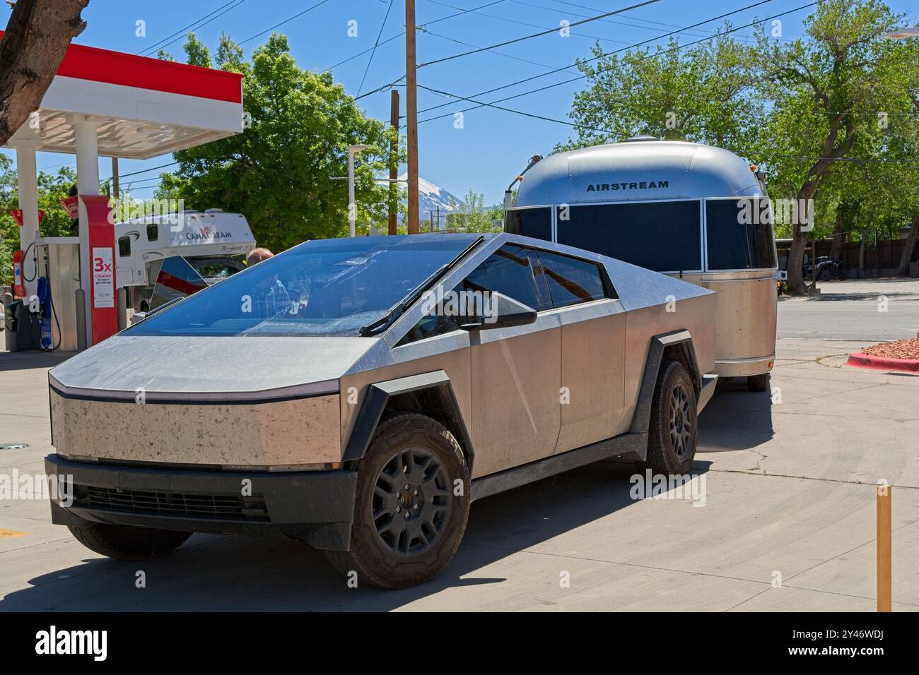 Tesla Cybertruck with Airstream trailer parked at gas station in ...