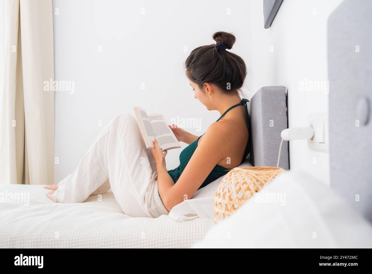 Side portrait of A young girl reading a book with mock text. sitting on ...