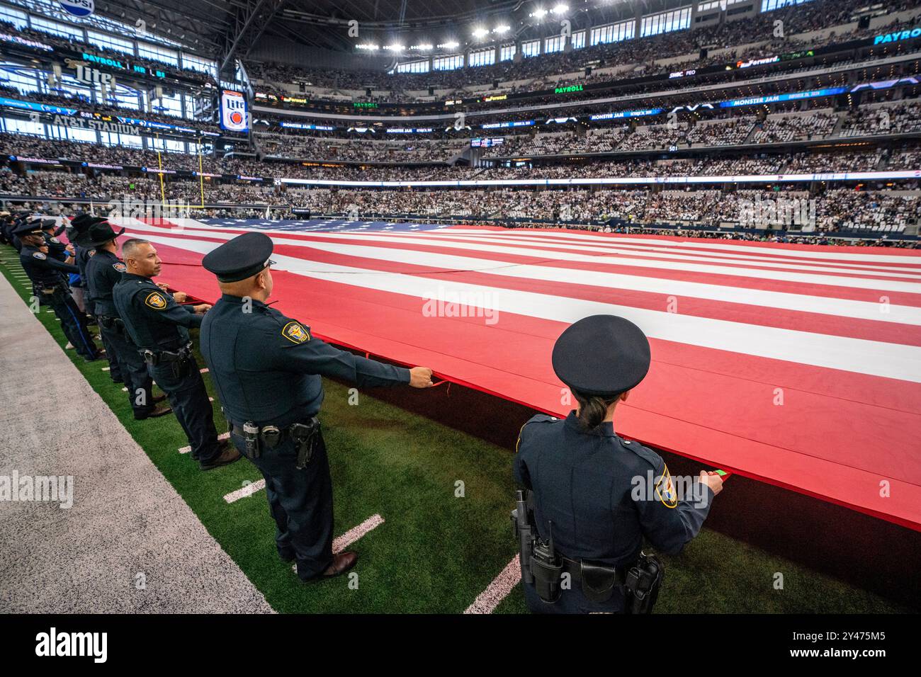 First responders hold a giant flag across the field before a football ...
