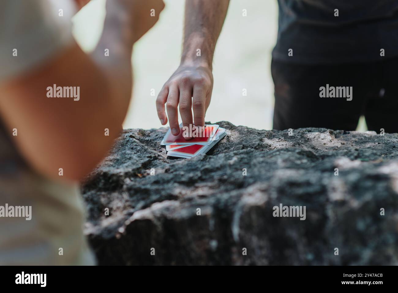 People playing card game outdoors on a stone surface Stock Photo - Alamy