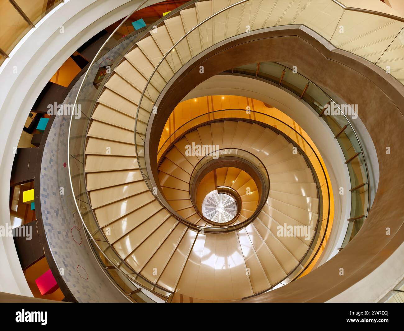 A beautifully designed spiral staircase in a modern building with glass ...