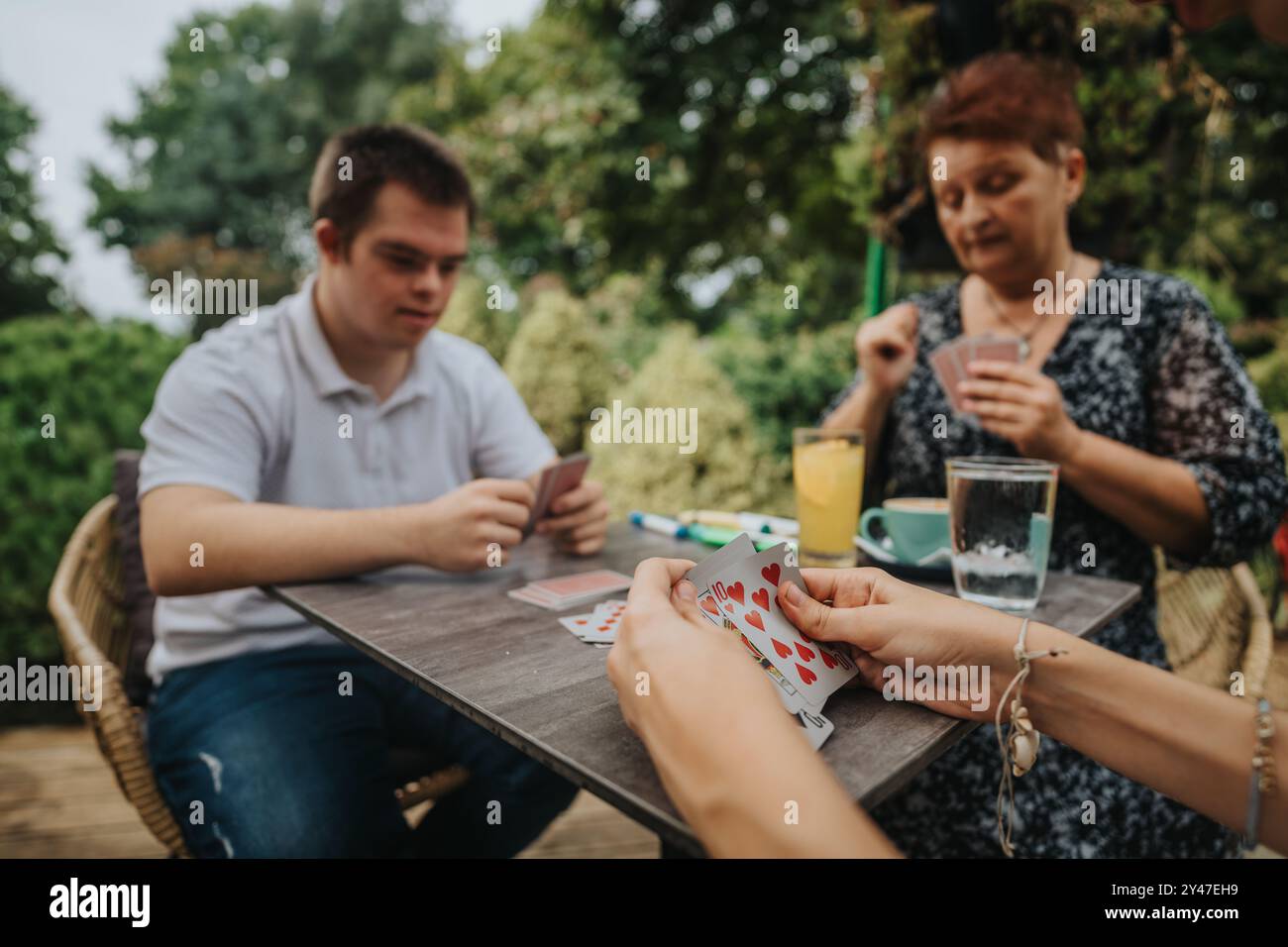 Family enjoying a card game outdoors for quality bonding time Stock ...