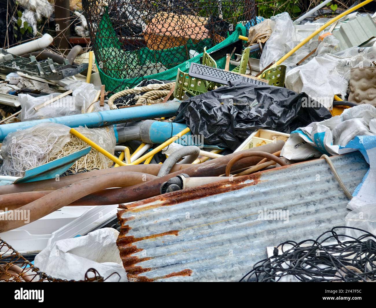 A pile of garbage with a bucket, rope, bottles, and other items at a ...