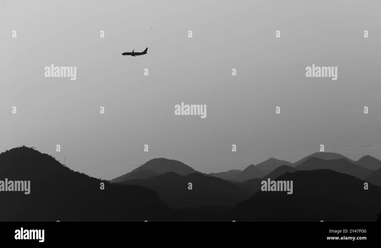 Jet plane flying over the mountains at sunrise. Silhouettes and various ...