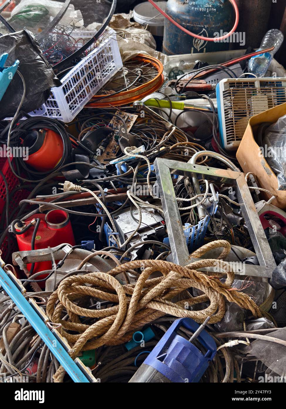 A pile of garbage with a bucket, rope, bottles, and other items at a ...
