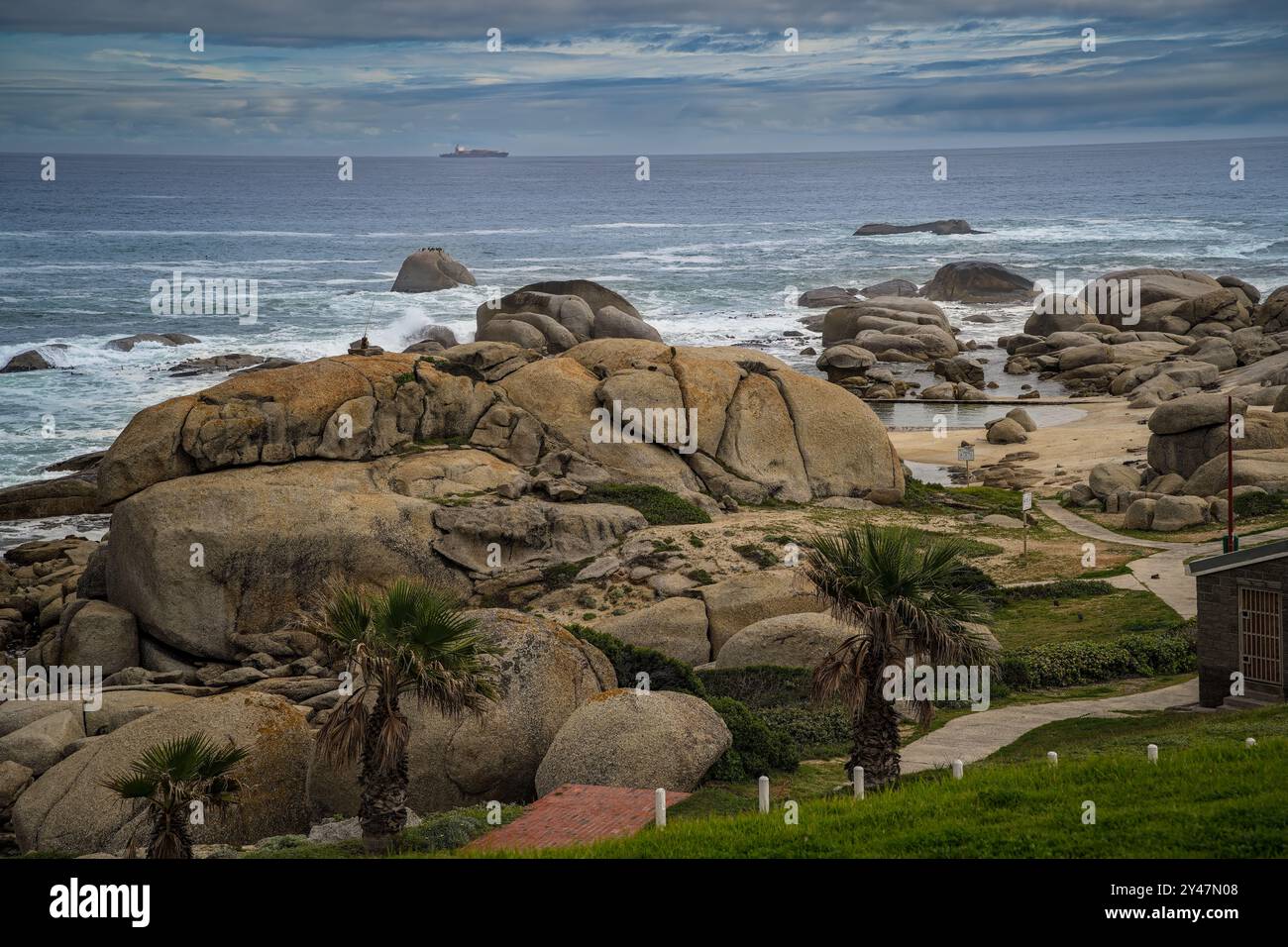 A photo that looks over large rocks on the beach in Cape Town South ...