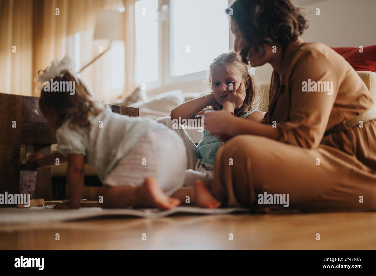 Mom with daughters enjoying playtime together in cozy living room ...