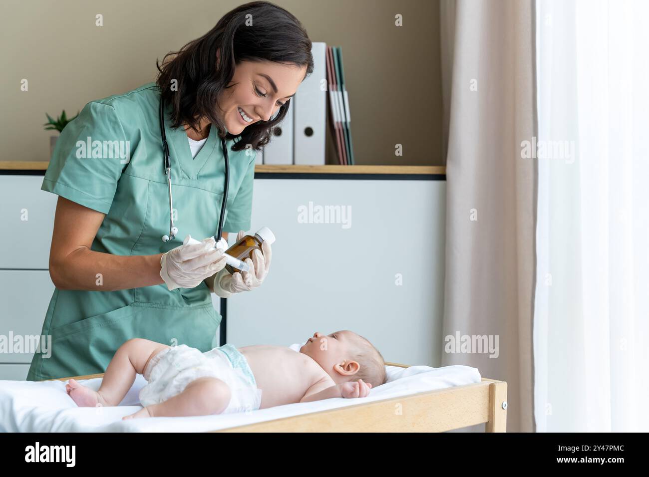 Doctor giving dose of syrup to sick baby in the clinic Stock Photo - Alamy