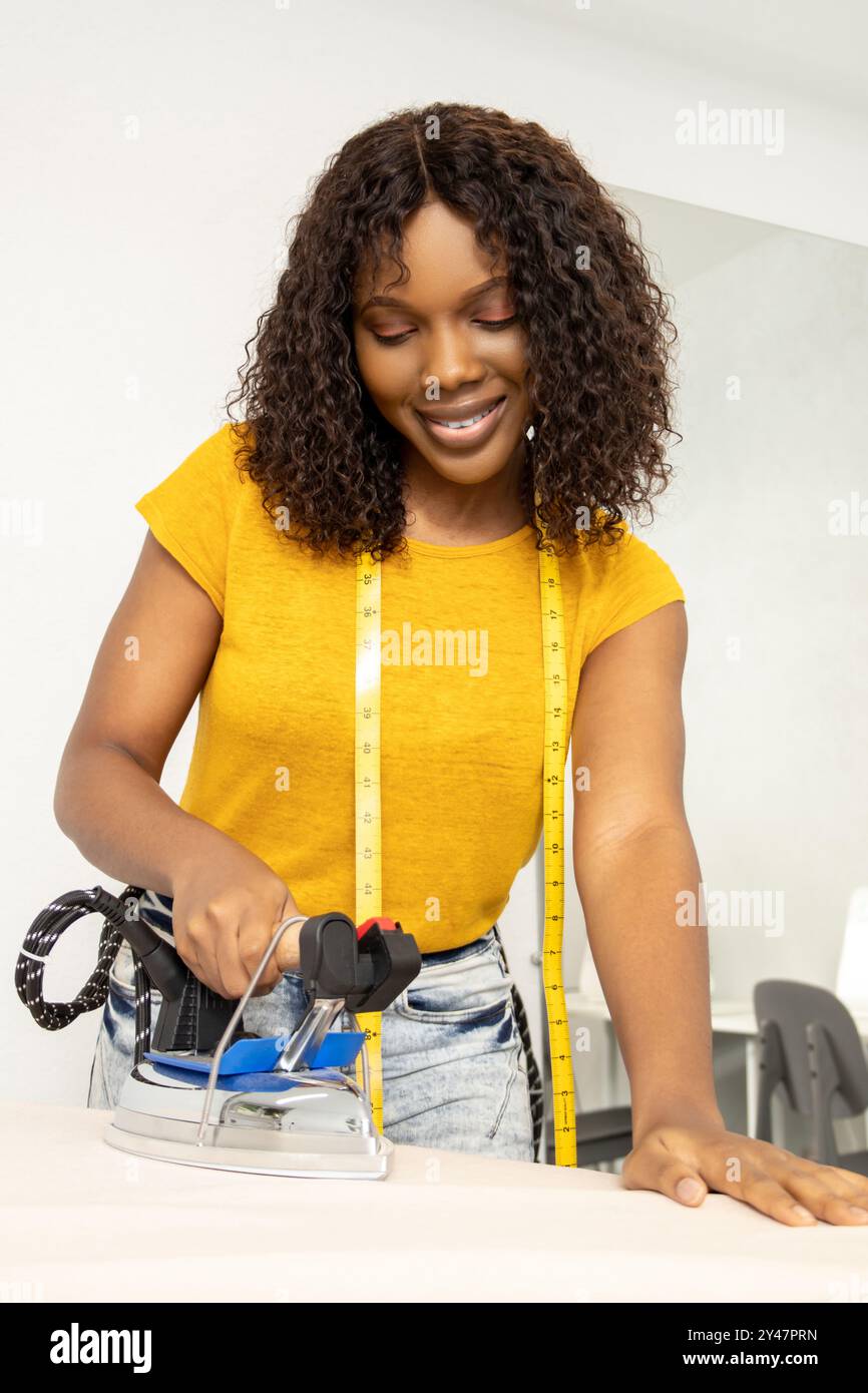 Dressmaker ironing a new model and looking contented and busy Stock ...