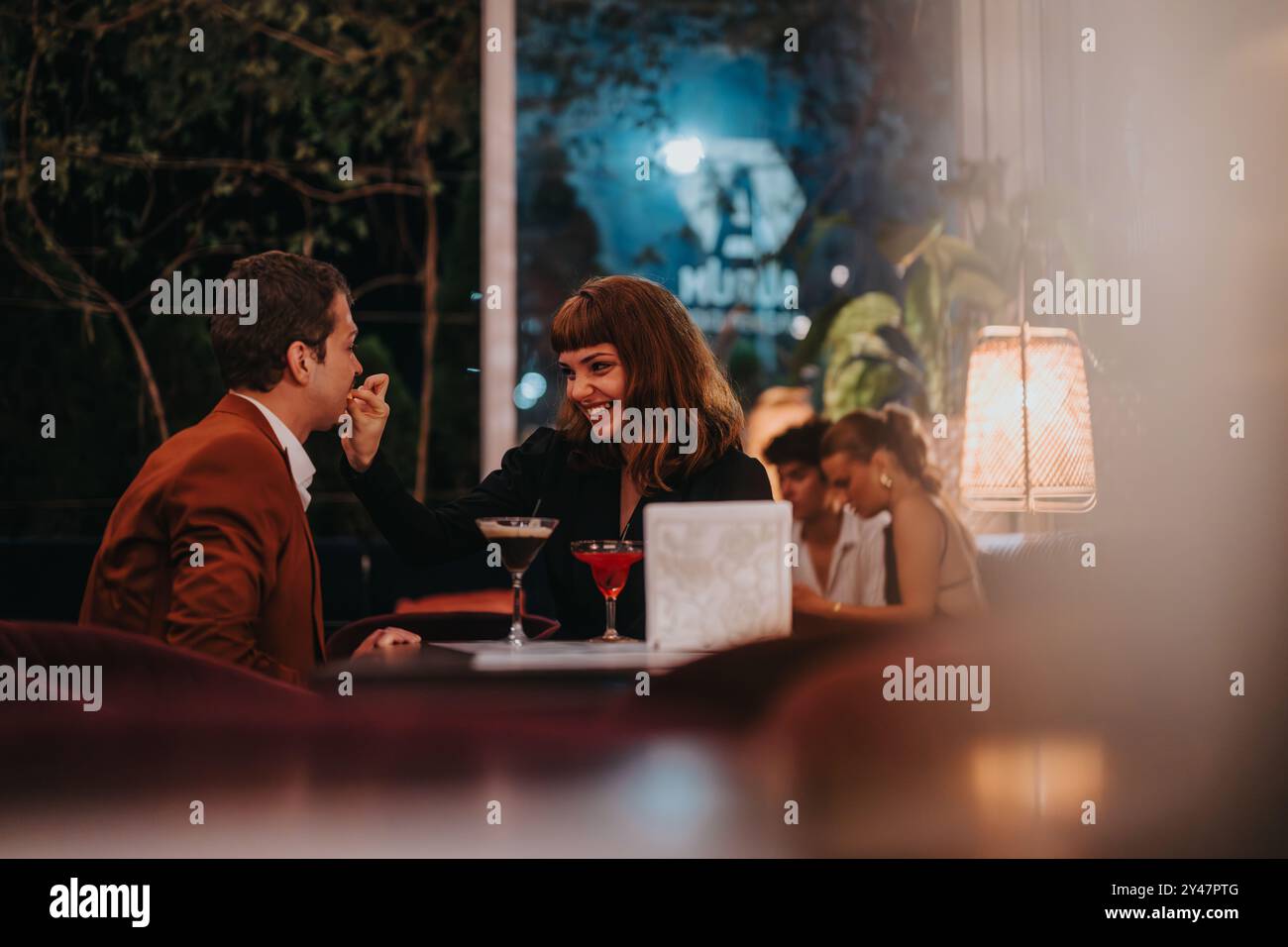 Romantic couple enjoying a date night at a cozy restaurant Stock Photo ...